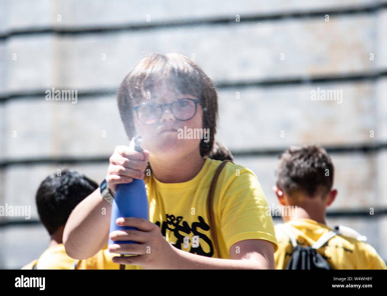 Young boy sprays water mist from his spray bottle at camera Stock Photo ...