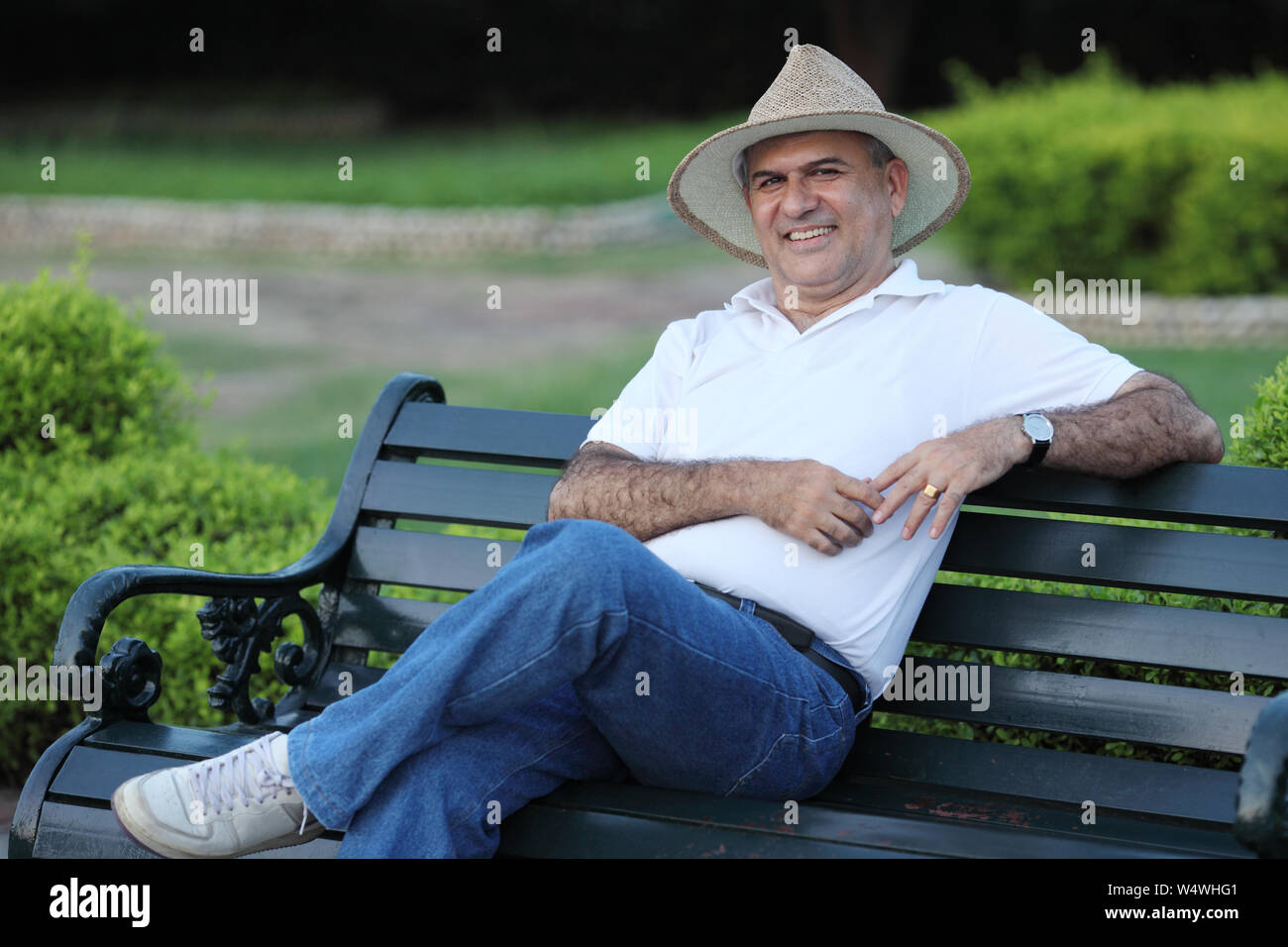 Man sitting on a park bench and smiling Stock Photo - Alamy
