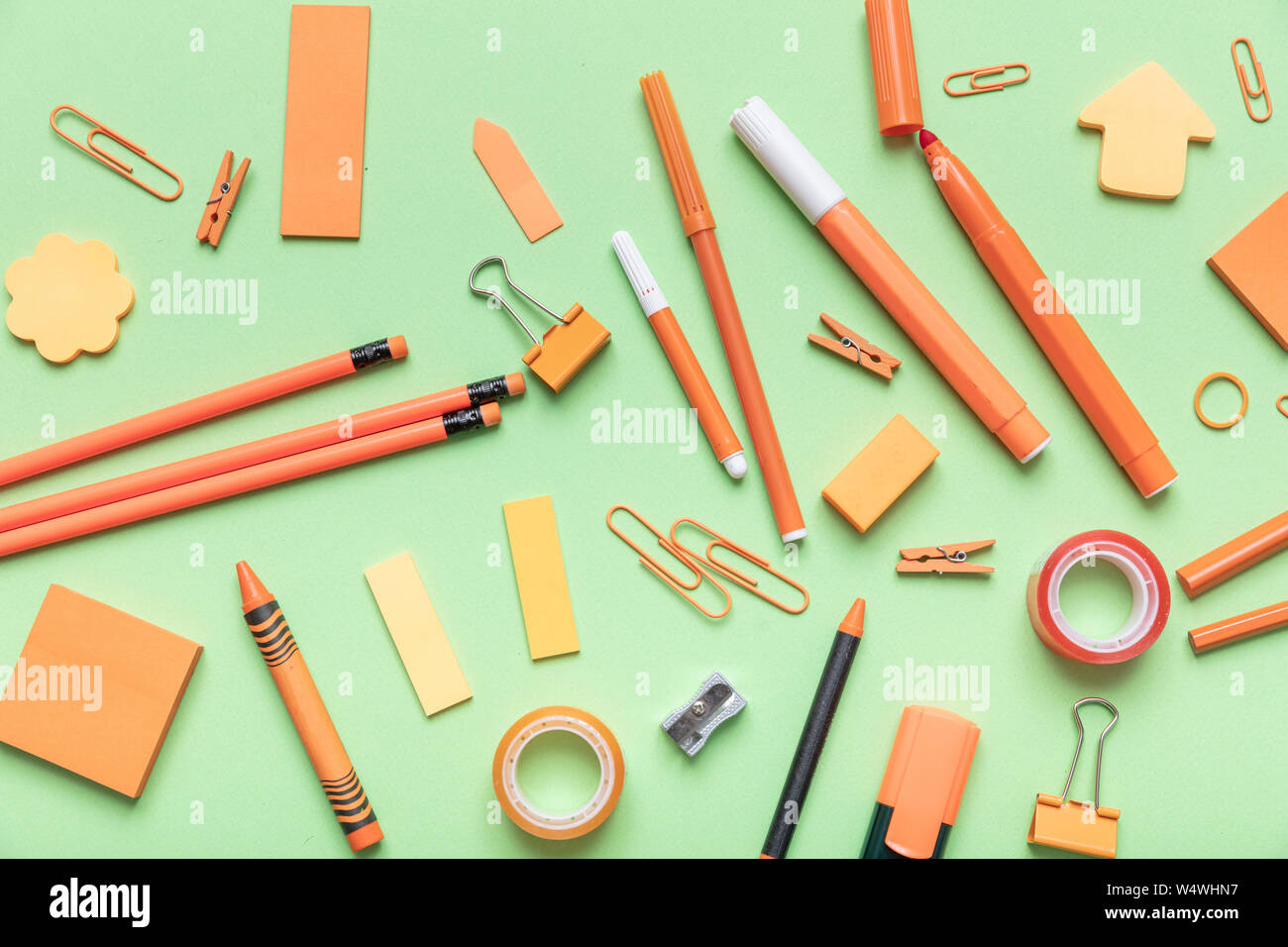 Back to school. School supplies orange color on green pastel background ...