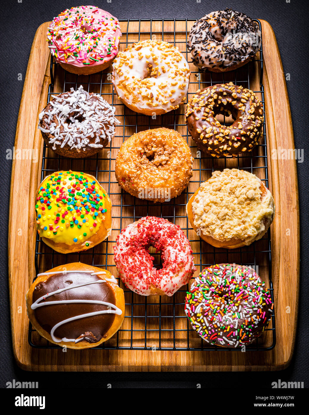 assorted donuts on wire rack on wooden cutting board Stock Photo - Alamy