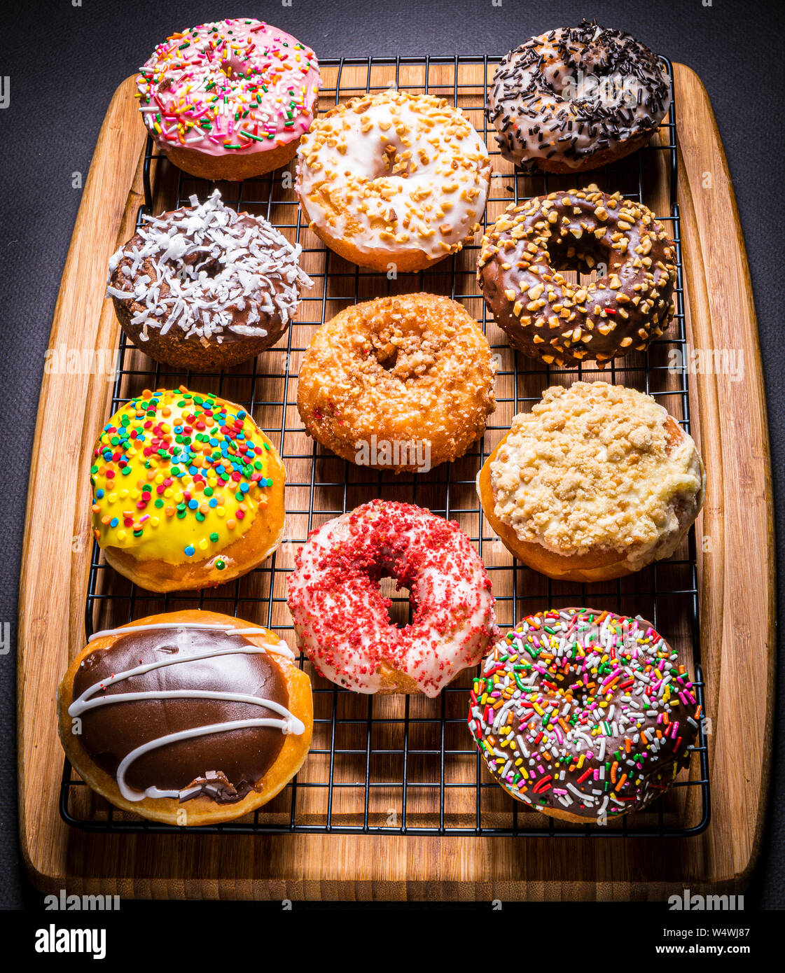 assorted donuts on wire rack on wooden cutting board Stock Photo - Alamy