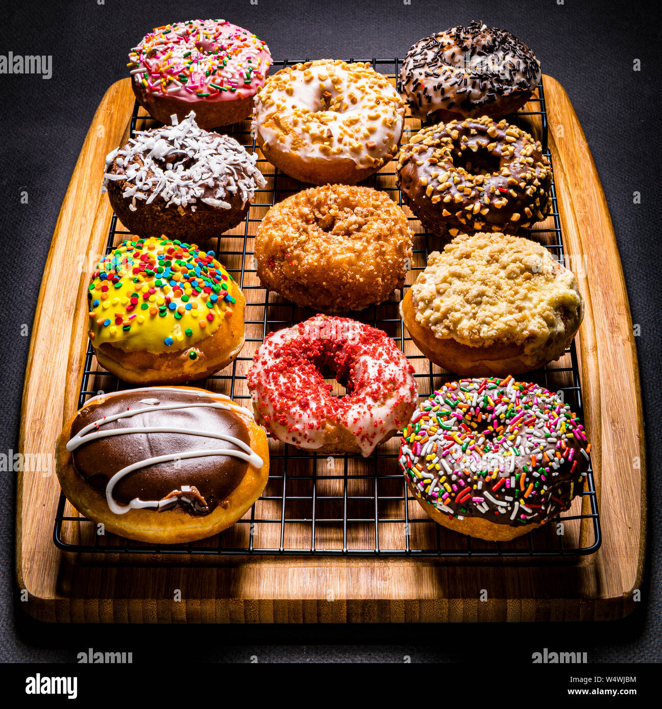 assorted donuts on wire rack on wooden cutting board Stock Photo - Alamy