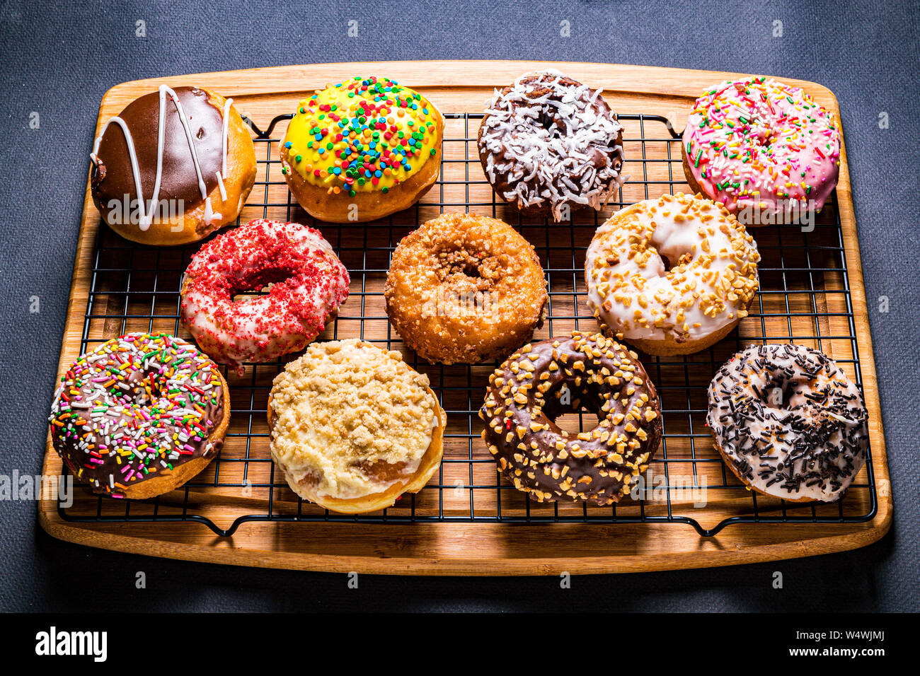 assorted donuts on wire rack on wooden cutting board Stock Photo - Alamy