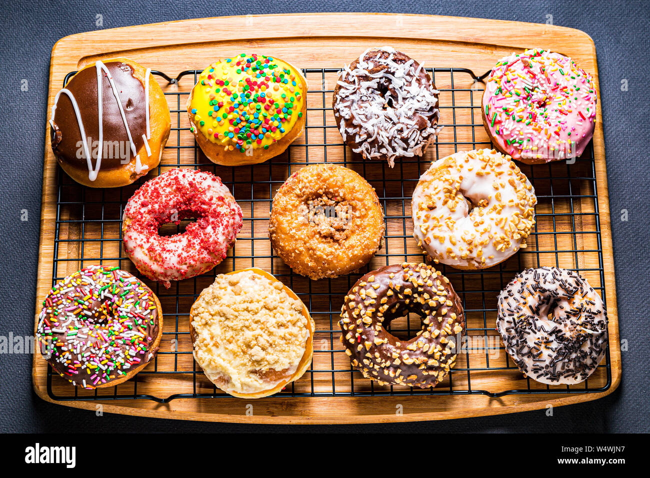 assorted donuts on wire rack on wooden cutting board Stock Photo - Alamy