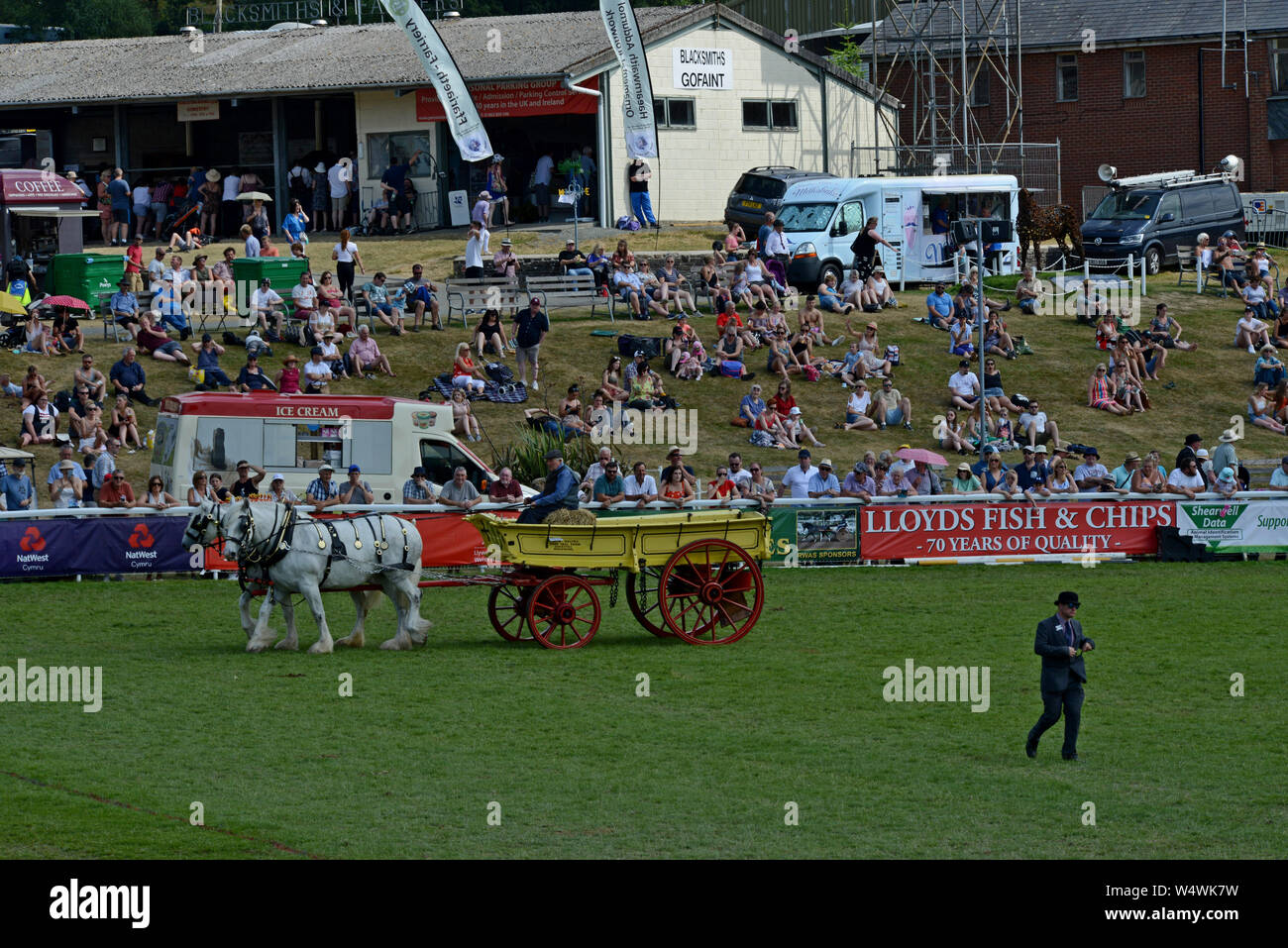 Builth Wells, UK. 25th July, 2019. People watch a parade of vintage ...