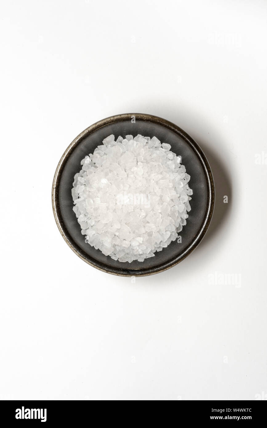 Rock salt in a small black bowl Stock Photo - Alamy