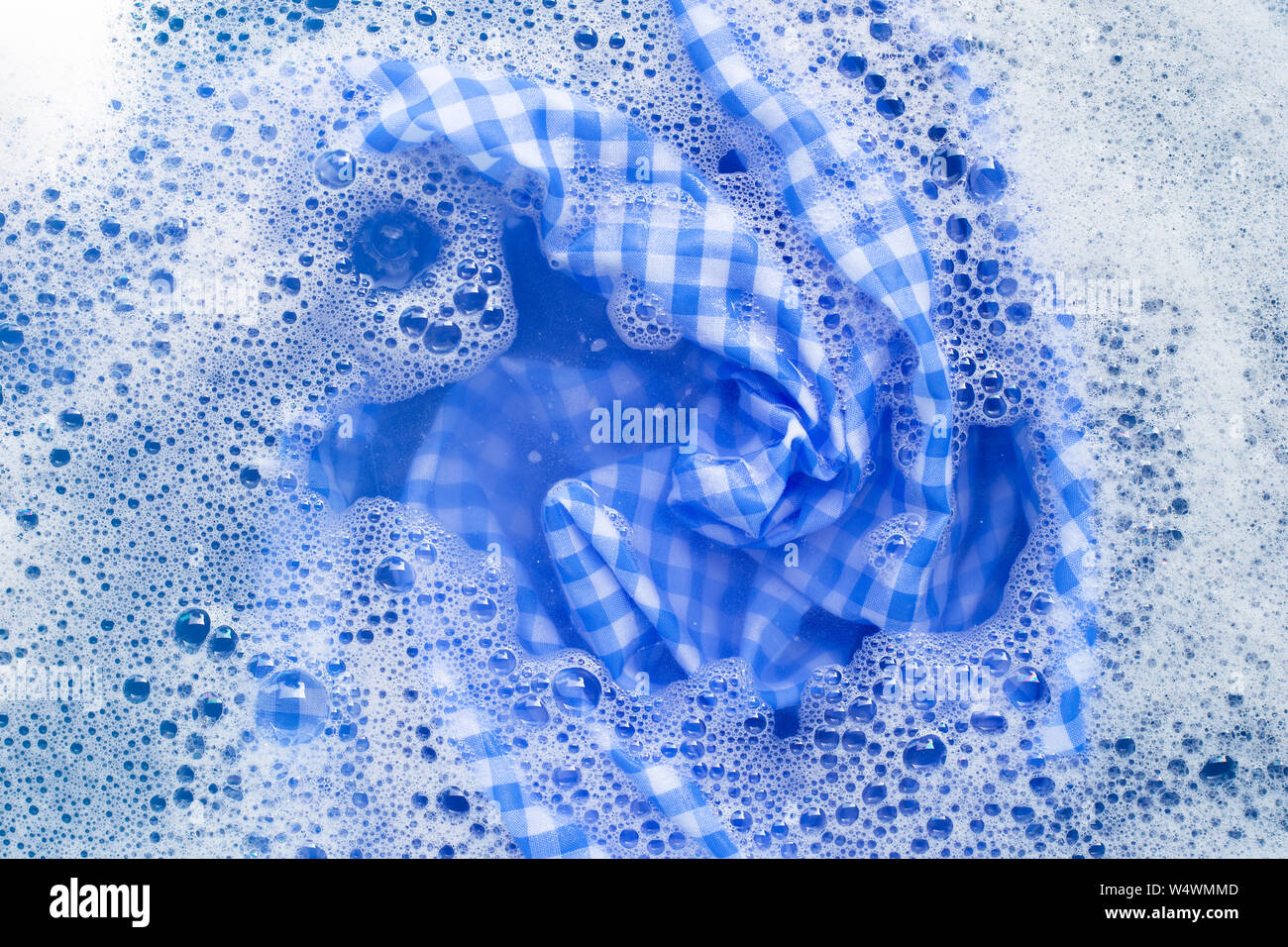 Blue white tablecloth soak in powder detergent water dissolution ...
