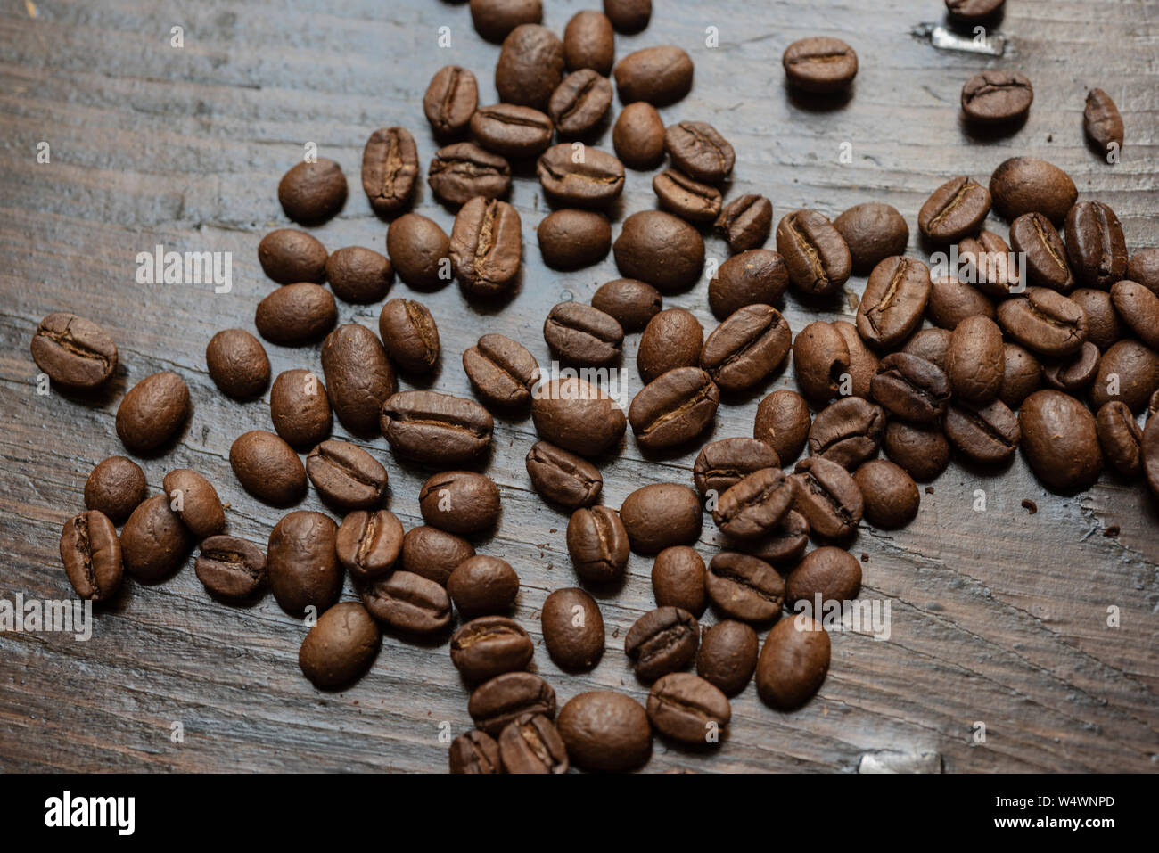Random grouping of coffee beans on a dark wood background Stock Photo ...