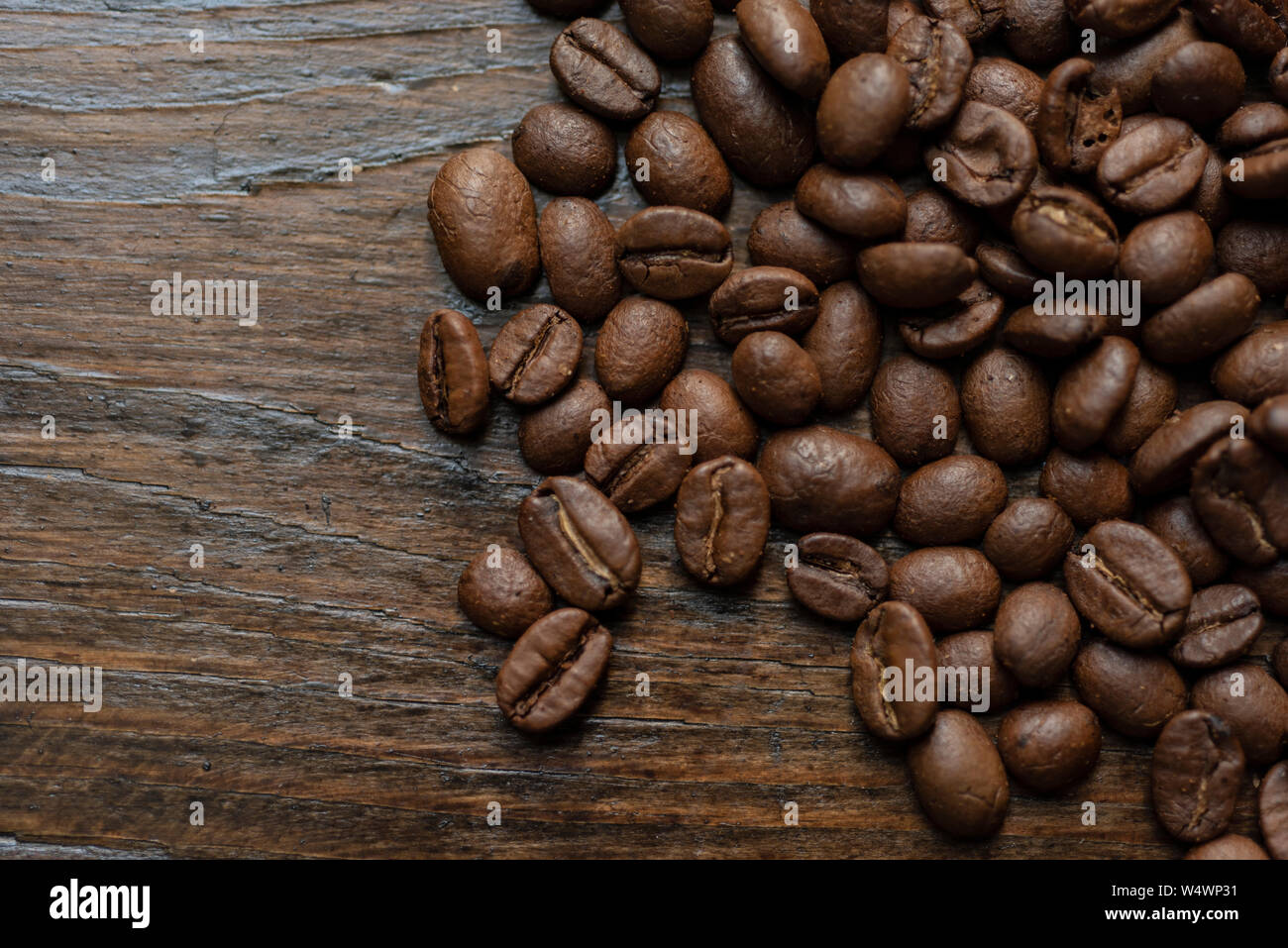Random grouping of coffee beans on a dark wood background Stock Photo ...