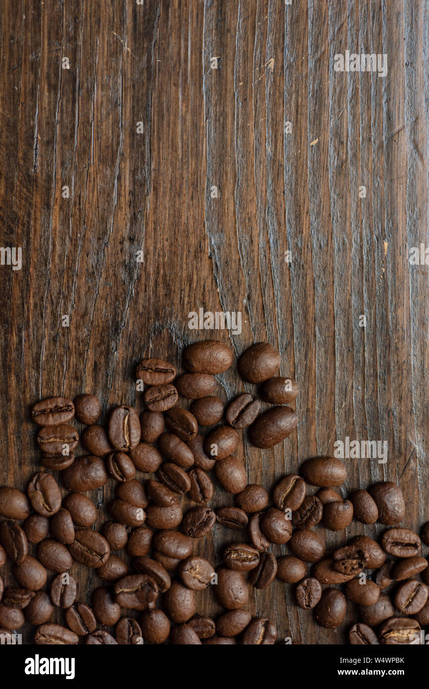 Random grouping of coffee beans on a dark wood background Stock Photo ...