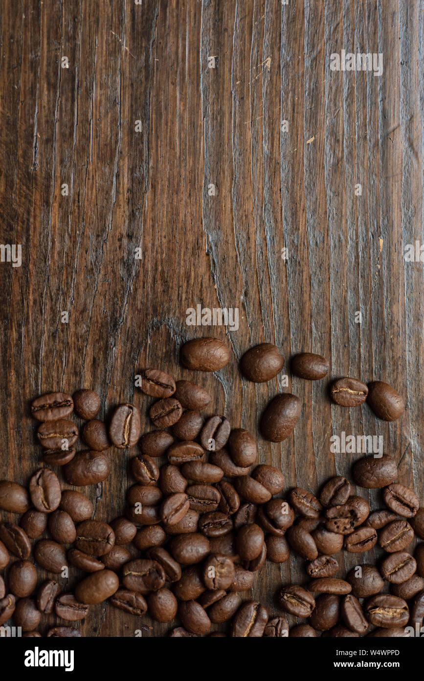 Random grouping of coffee beans on a dark wood background Stock Photo ...