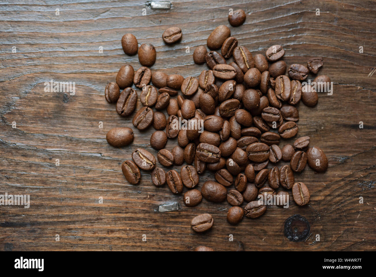 Random grouping of coffee beans on a dark wood background Stock Photo ...