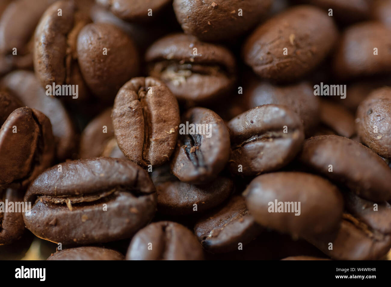 Random grouping of coffee beans on a dark wood background Stock Photo ...