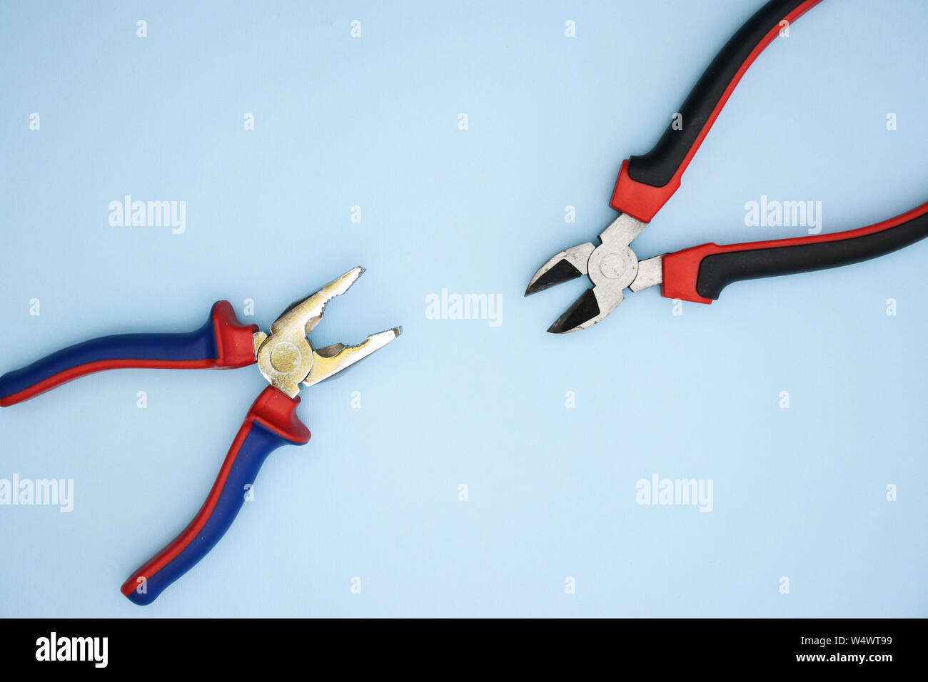 Two pliers on the blue background Stock Photo - Alamy