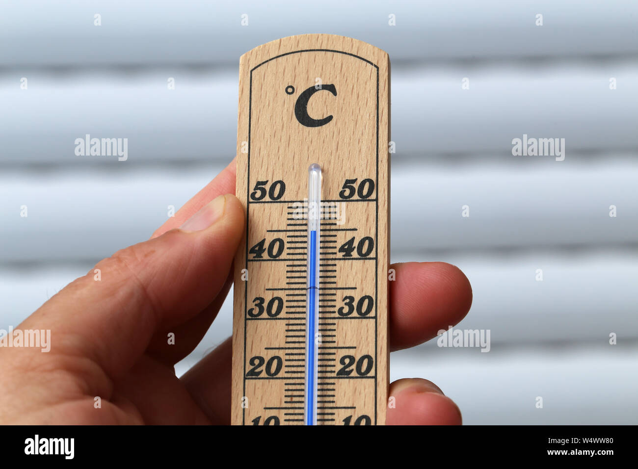 Hot Summer - Thermometer in hand, shows the heat Stock Photo - Alamy