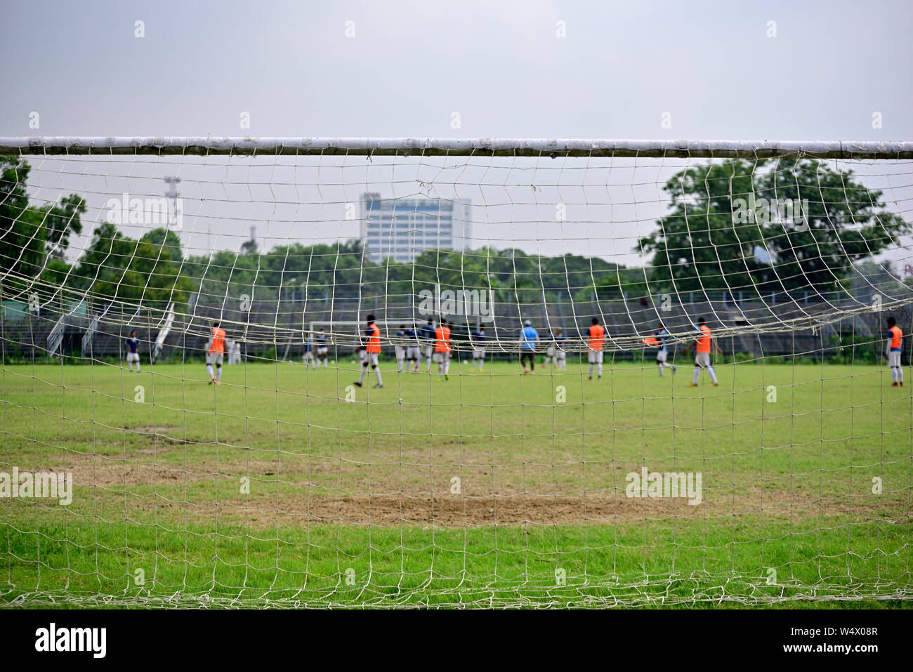 Boys are playing soccer in soccer field, Picture is captured behind ...
