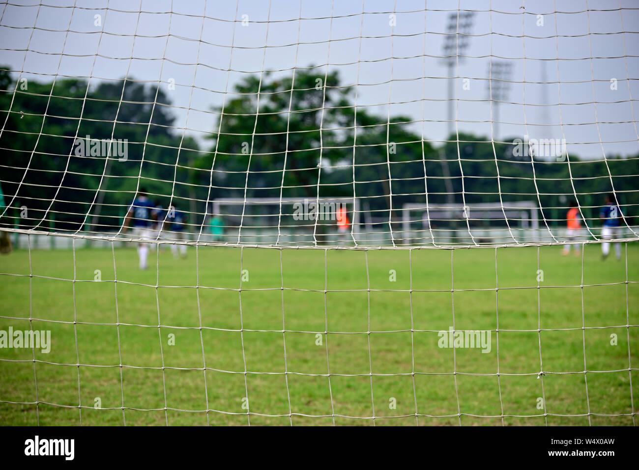 Boys are playing soccer in soccer field, Picture is captured behind ...