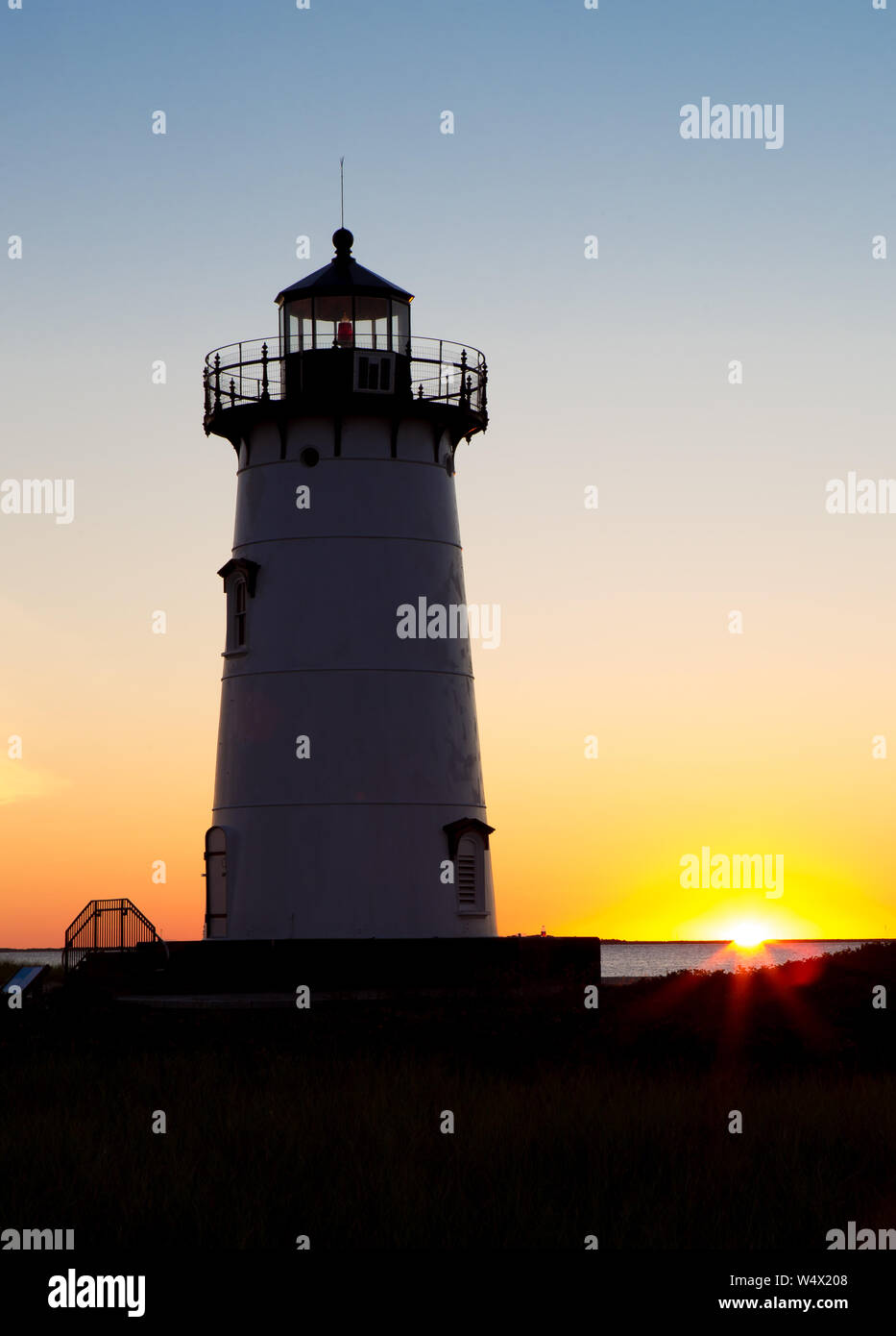 Sun peaks over the horizon at Edgartown Lighthouse in Marth's Vineyard ...