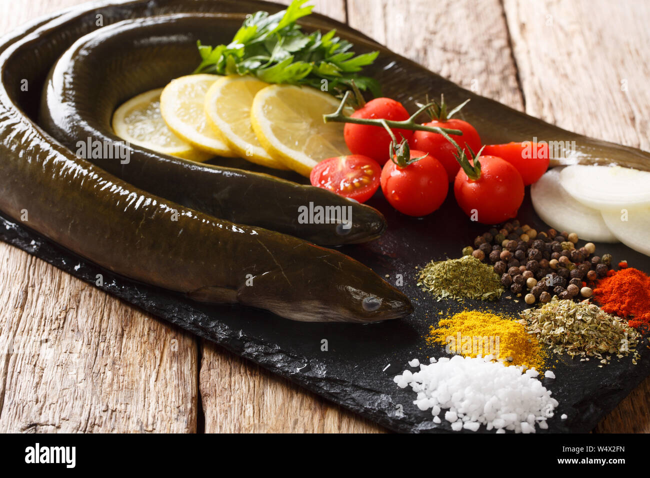 Fresh raw eel with ingredients close-up on a slate board on the table ...