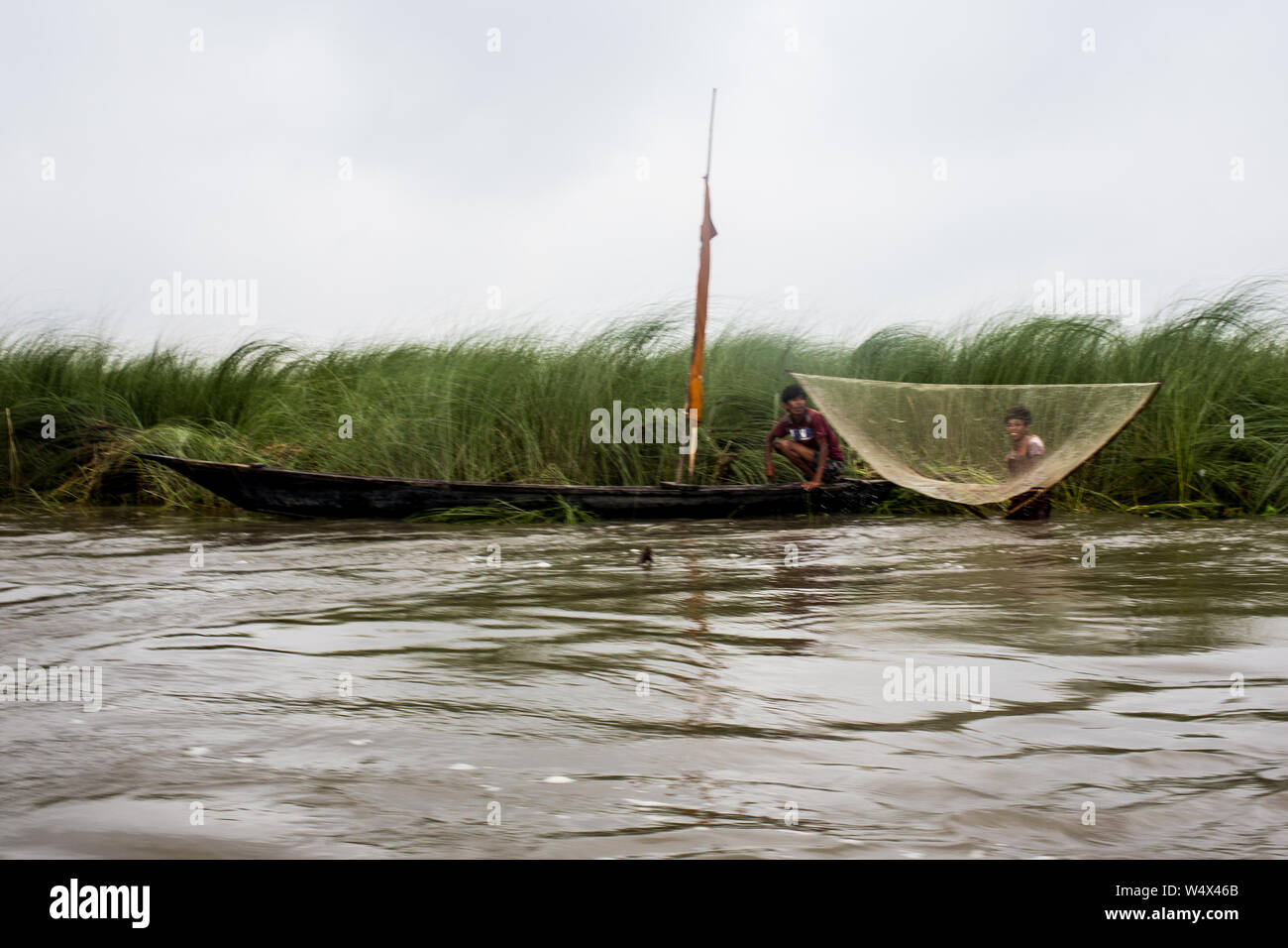 Young guys are fishing on the water of flood Stock Photo - Alamy