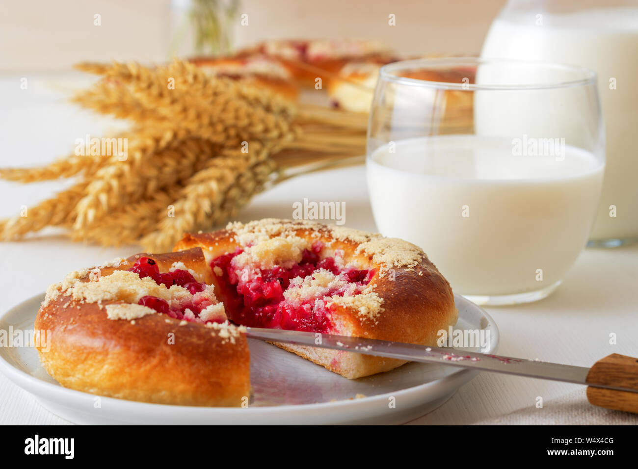 White table with yeasty sweet pastry with fresh currants and ...