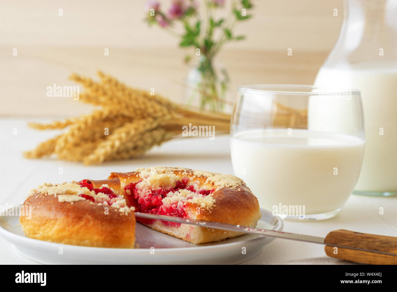 White table with yeasty sweet pastry with fresh currants and ...