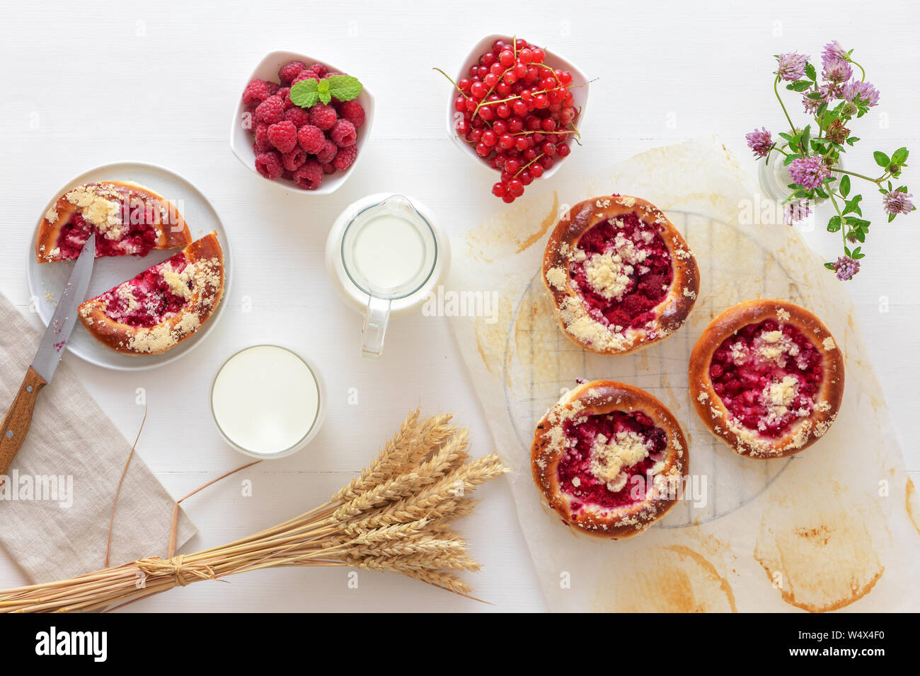 White table with yeasty sweet pastry with fresh currants and ...