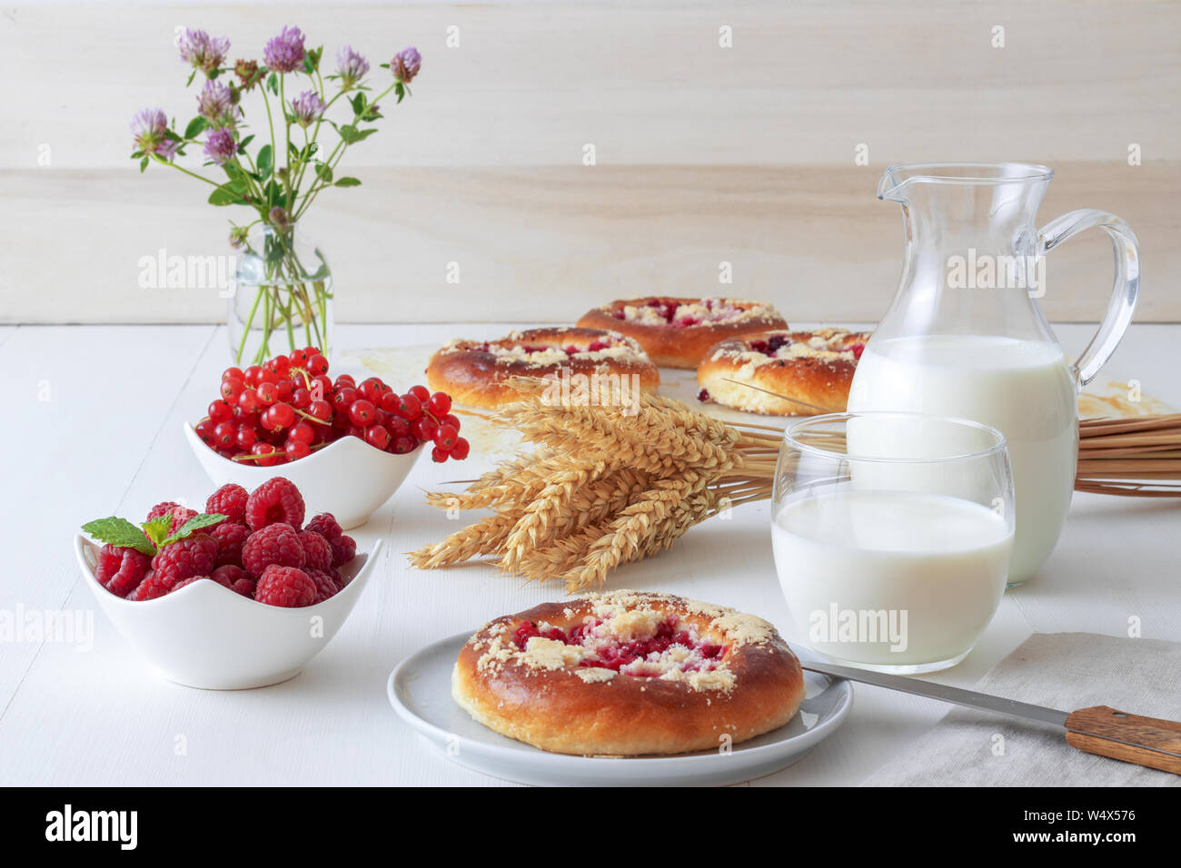 White table with yeasty sweet pastry with fresh currants and ...