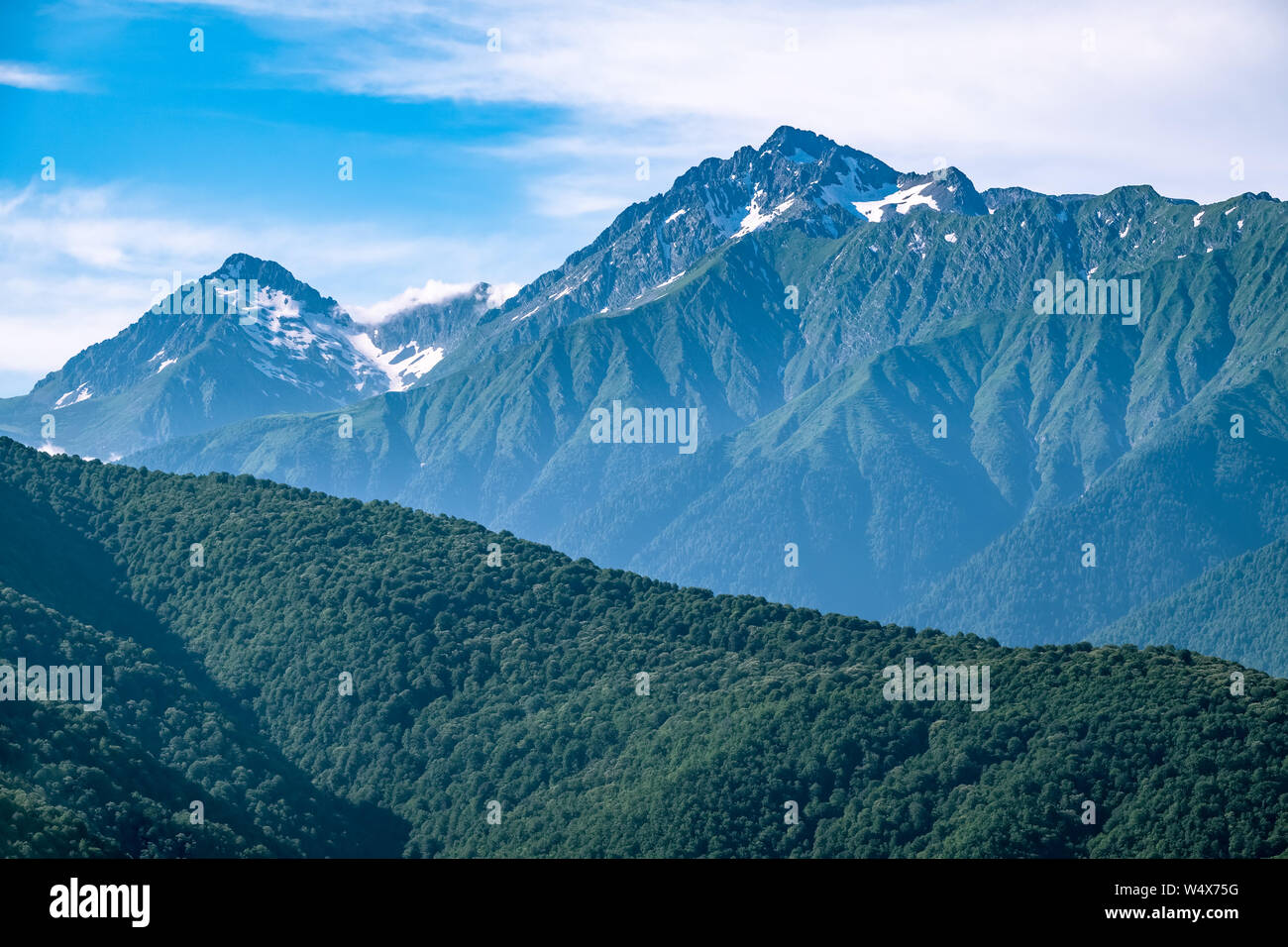 High mountains with green slopes and snowy peaks. Mountain ranges in ...