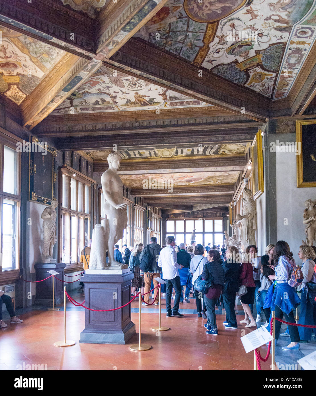 FLORENCE, ITALY - MAY 10, 2019: Tourists walk through the halls of the ...