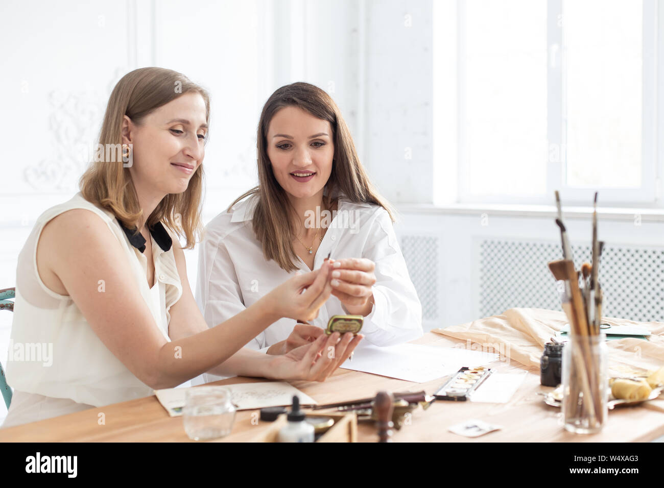 Learning calligraphy in art workshop. Teacher and students. Art school ...