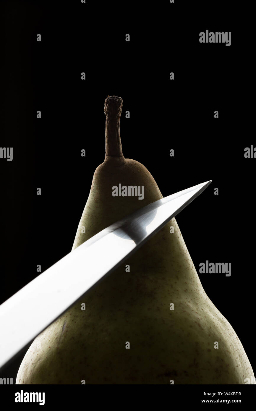 A pear nad knife against dark background Stock Photo - Alamy