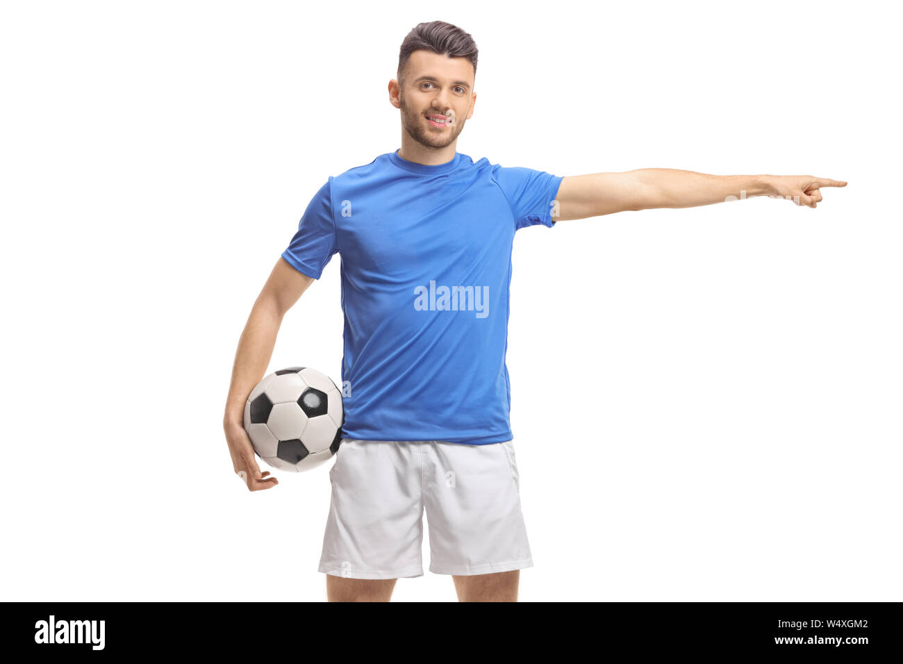 Soccer player holding a football and pointing to the side isolated on ...