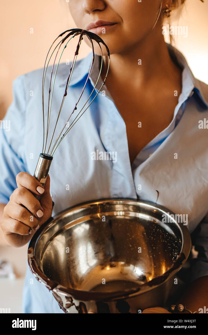 Female hands holding a metal whisk. Isolated on gray background ...