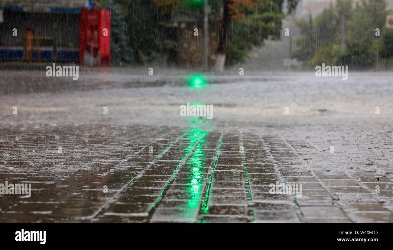 At the crossroads of the road, the green light of a traffic light is ...