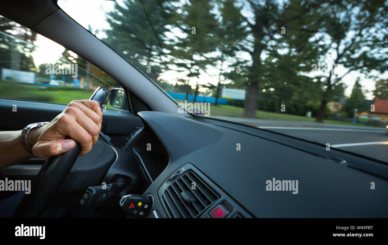 Hands of a driver on a wheel of a car (motion blurred image Stock Photo ...