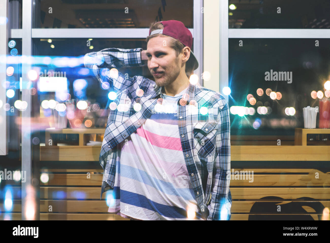 young smiling man portrait at night. standing next to the coffee shop ...