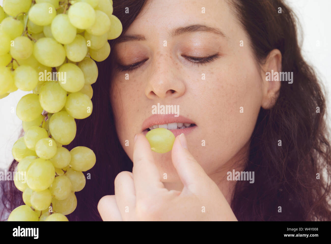Woman eating grapes hi-res stock photography and images - Alamy