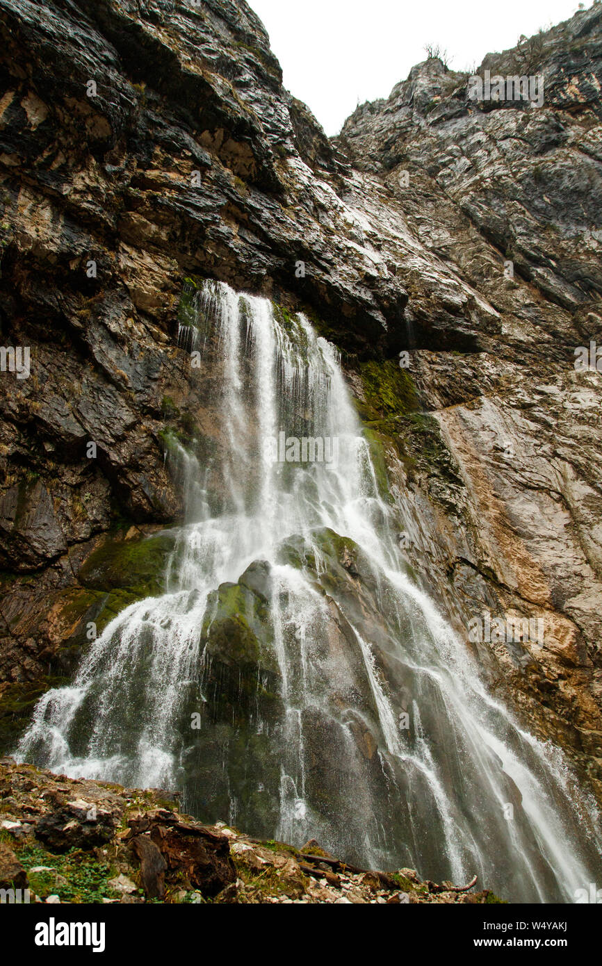 Small cliffy mountain spring waterfall in Abkhazia. Craggy ridge cliff ...