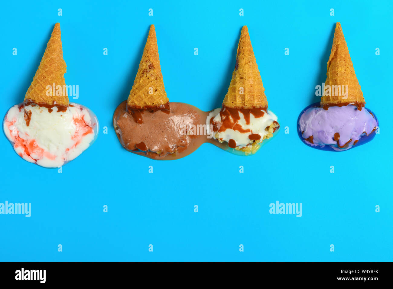 top view mini ice cream cones in a melting process on a blue background ...