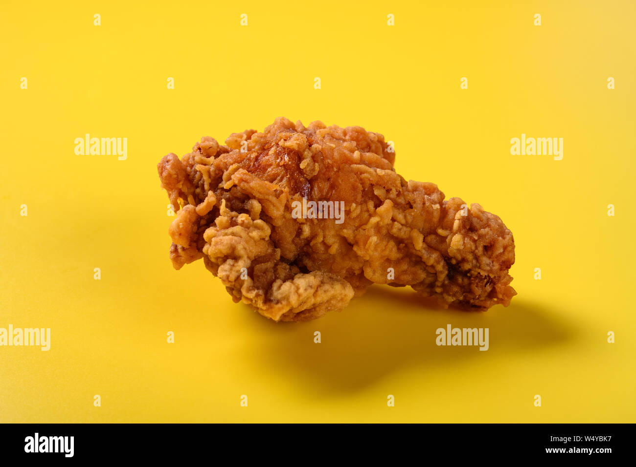 side view fresh deep fried chicken drumstick on yellow background Stock ...