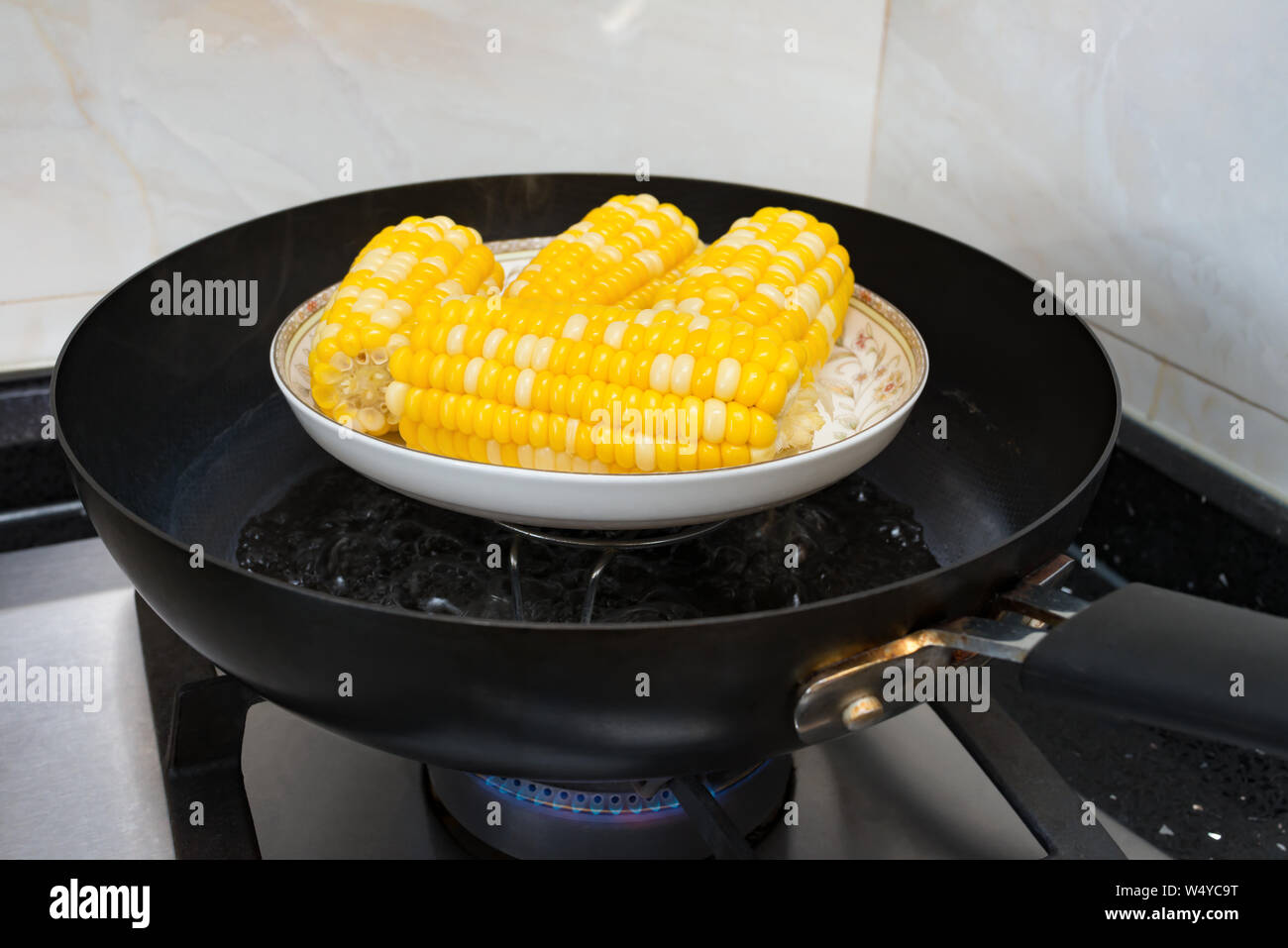 steaming fresh maizes on a wok Stock Photo - Alamy