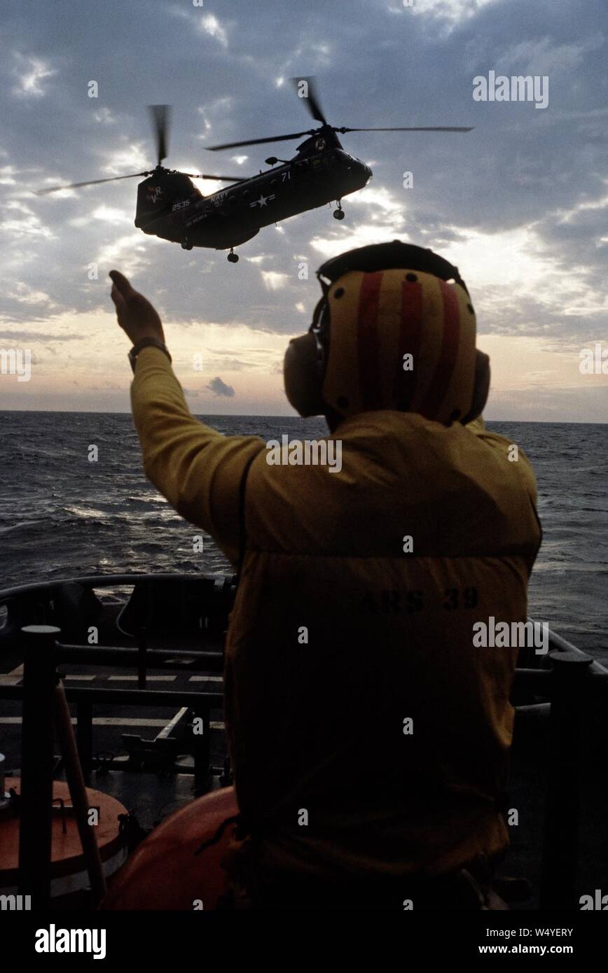 Crewman aboard USS Conserver (ARS-39) signals a UH-46D Sea Knight of HC ...
