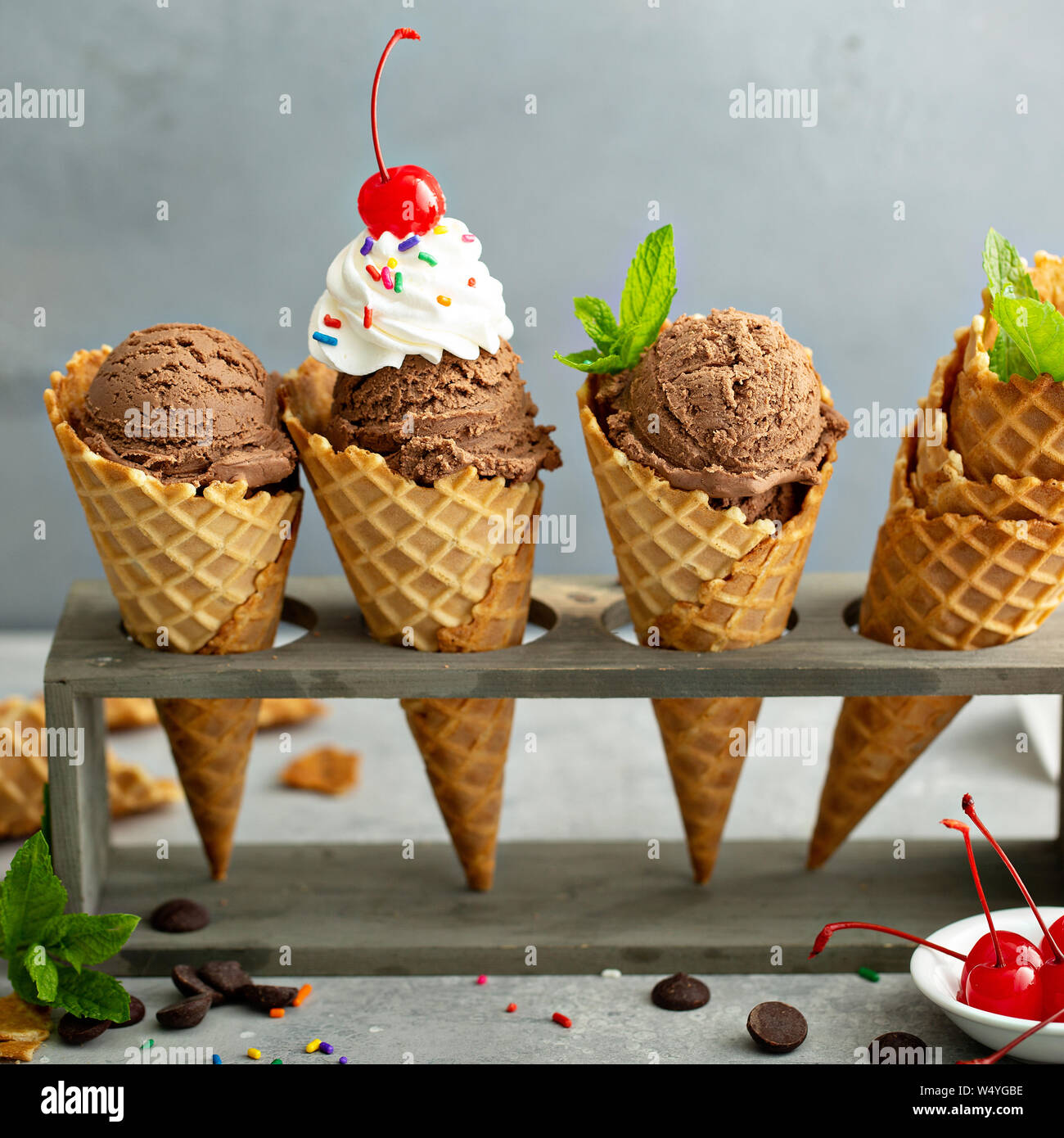 Chocolate ice cream in waffle cones with whipped cream and sprinkles ...