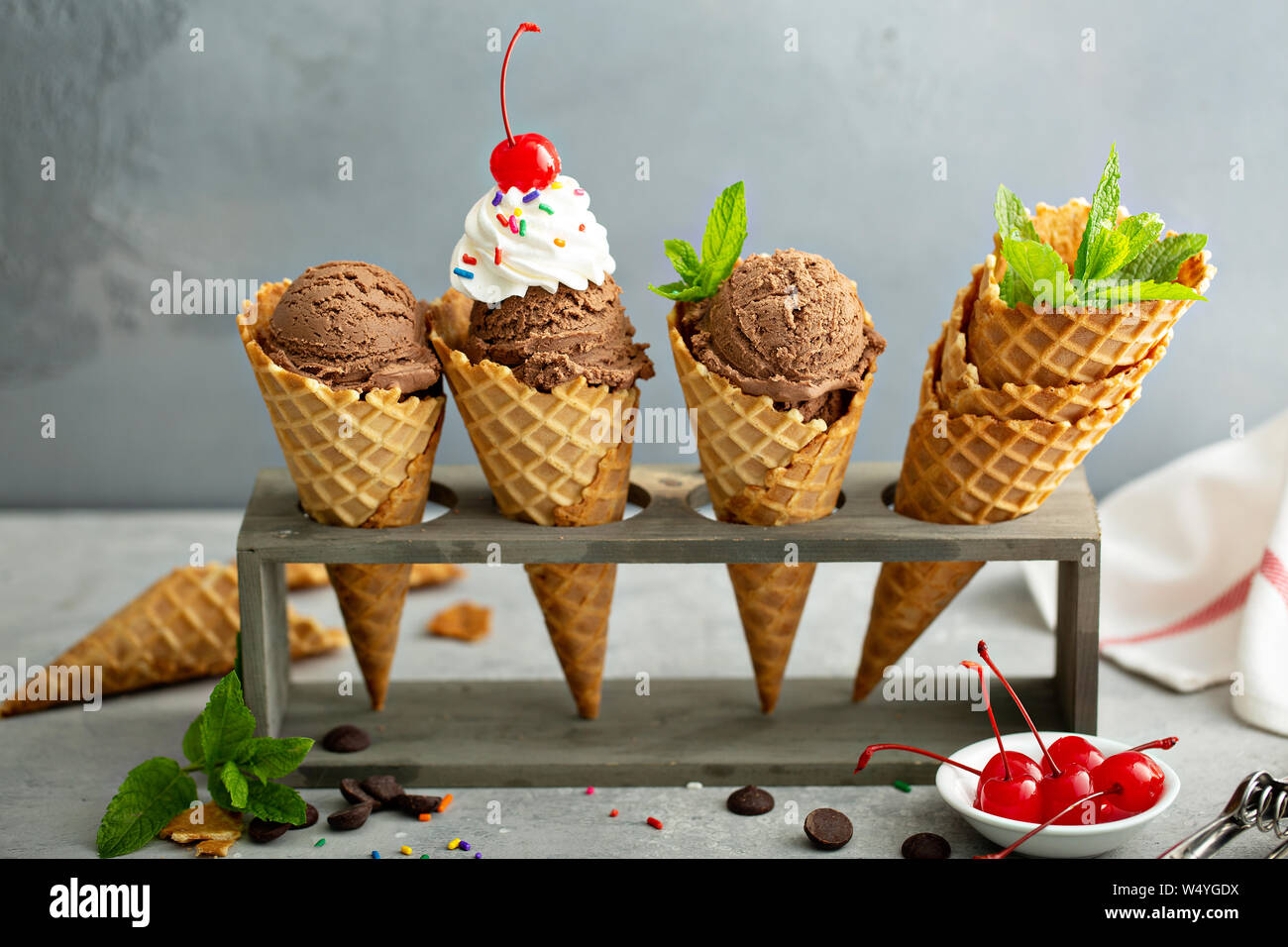 Chocolate ice cream in waffle cones with whipped cream and sprinkles ...