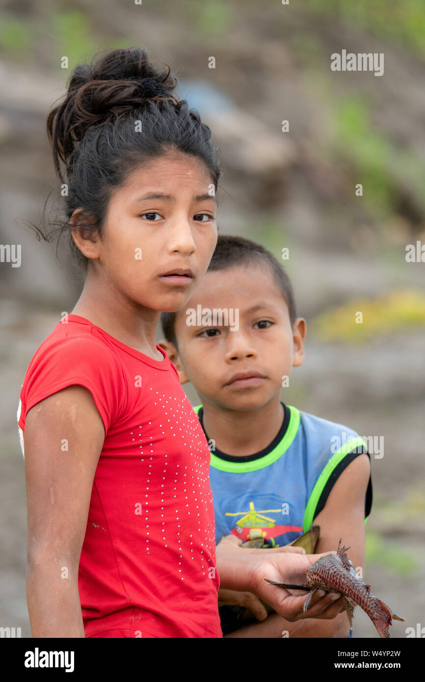 Young girl and boy (Riberenos) shoot curious glances in the Peruvian ...