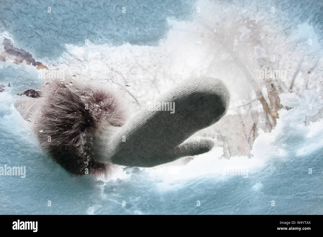 hand in mitten cleaning window of car from the snow, inside view Stock ...