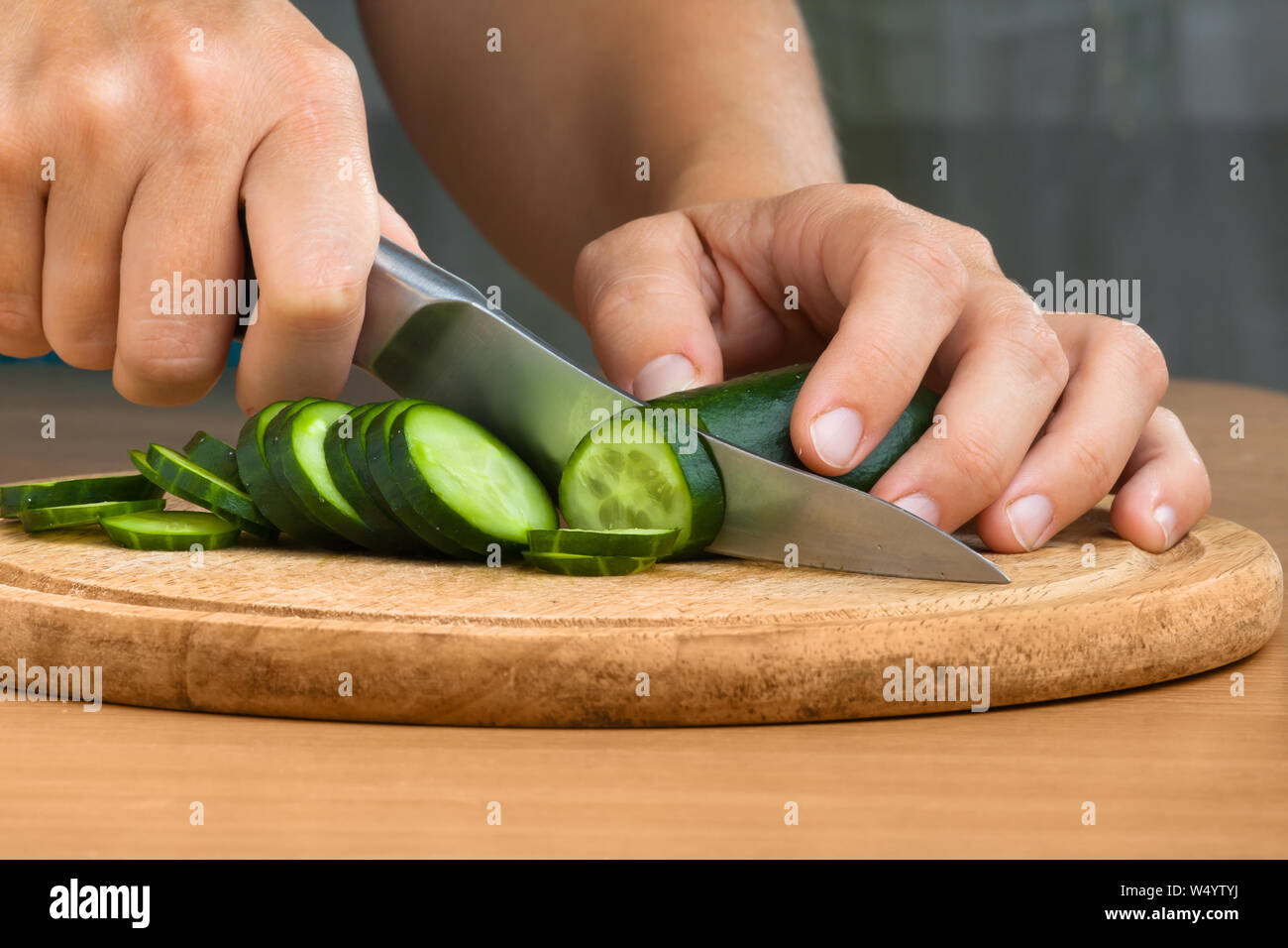 Woman cutting cucumber on wooden hi-res stock photography and images ...