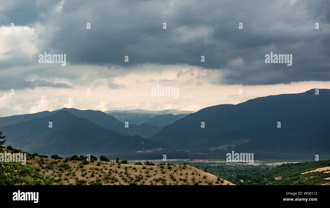 Dramatic stormy mountain peak and dark forest hi-res stock photography ...