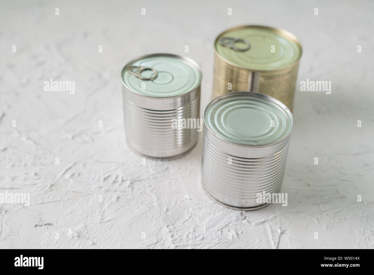 many unopened tin cans with meals such as meat and fish on the table ...